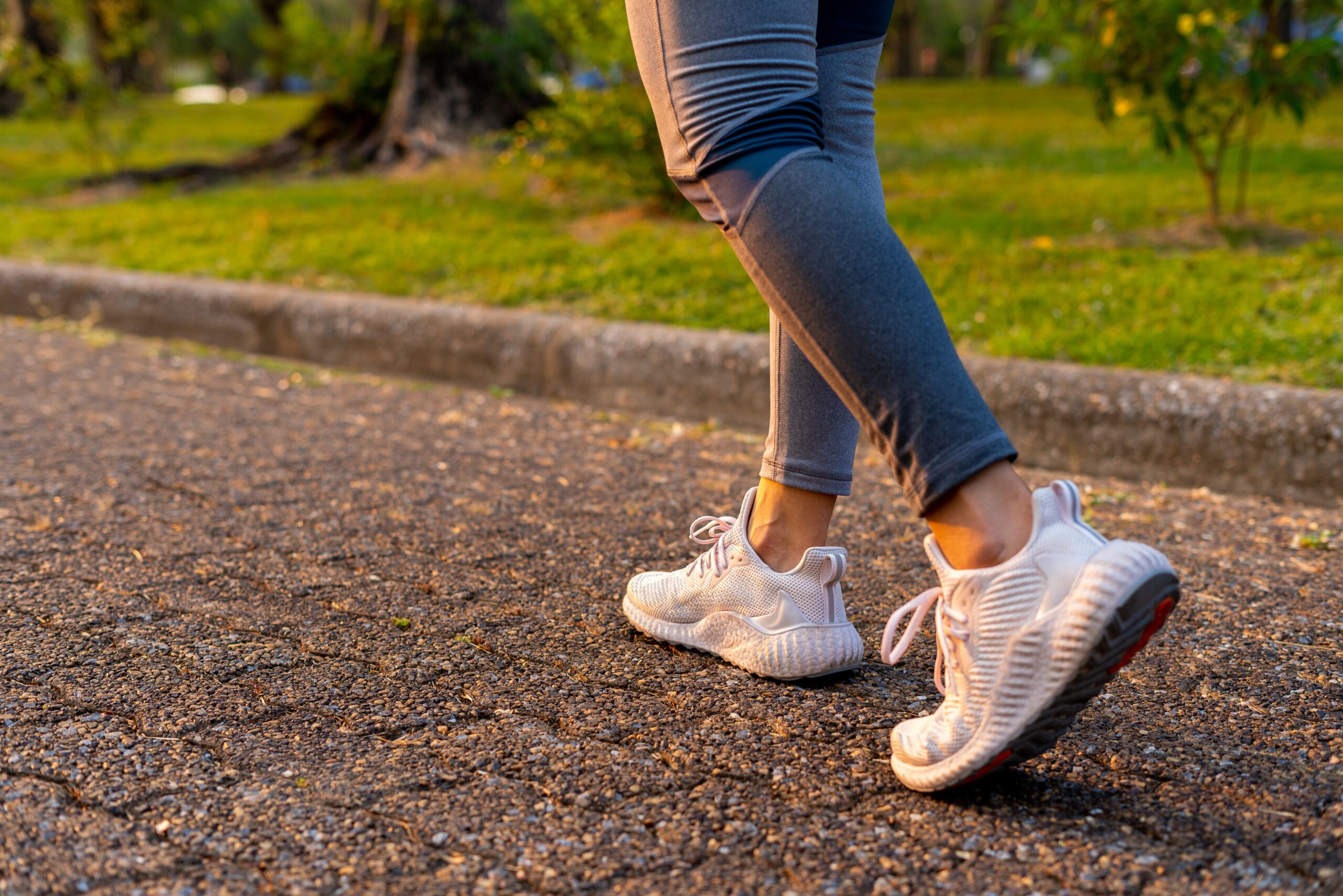 Young woman walking exercise on a brown street with white shoes | Cabot ...